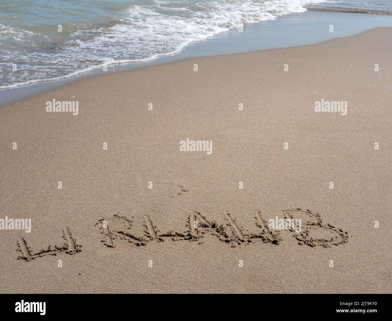 Writing in the sand 'vacation' symbol Stock Photo - Alamy