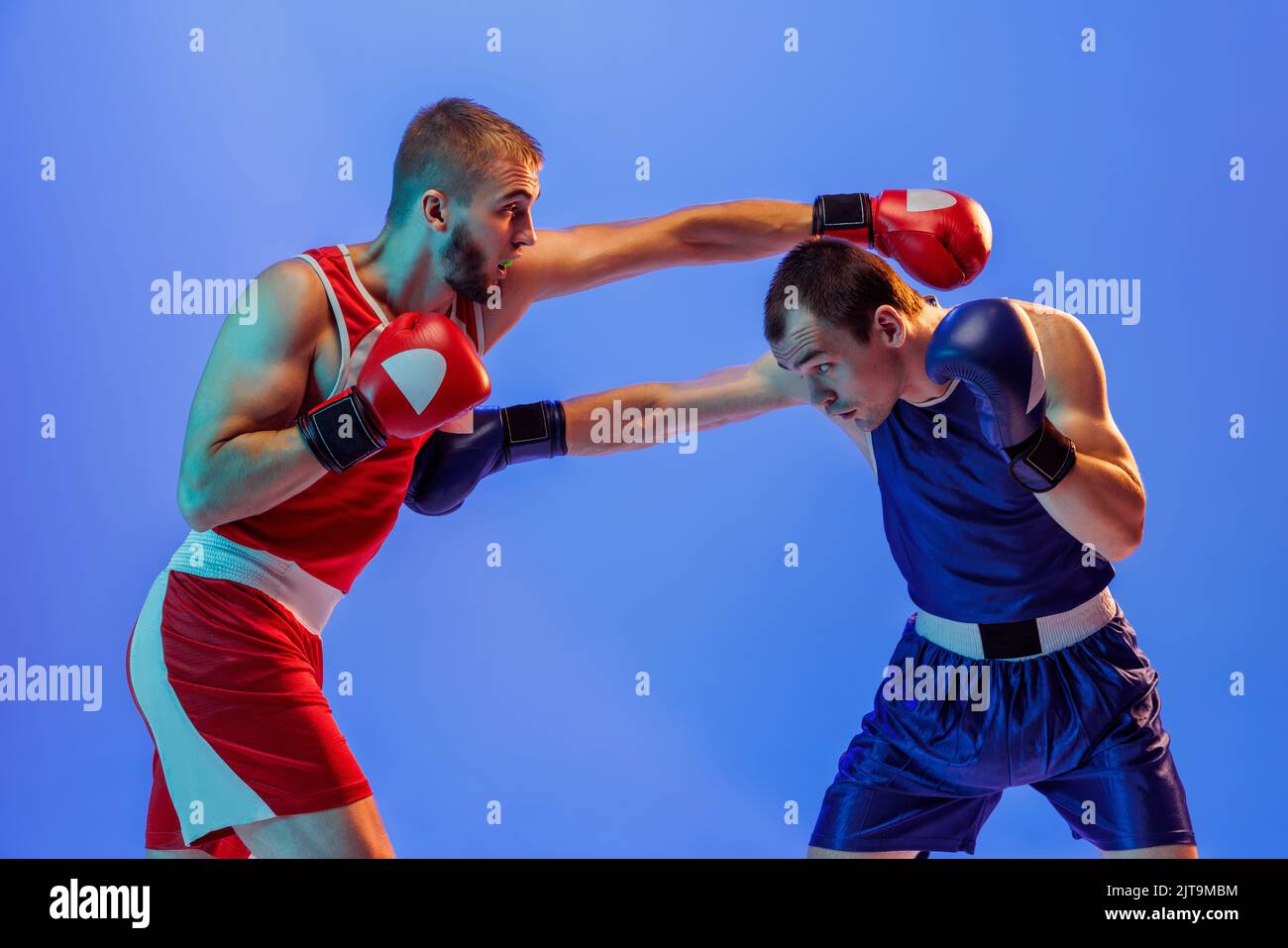 Studio shot of male professional boxers in red and blue sports uniform ...