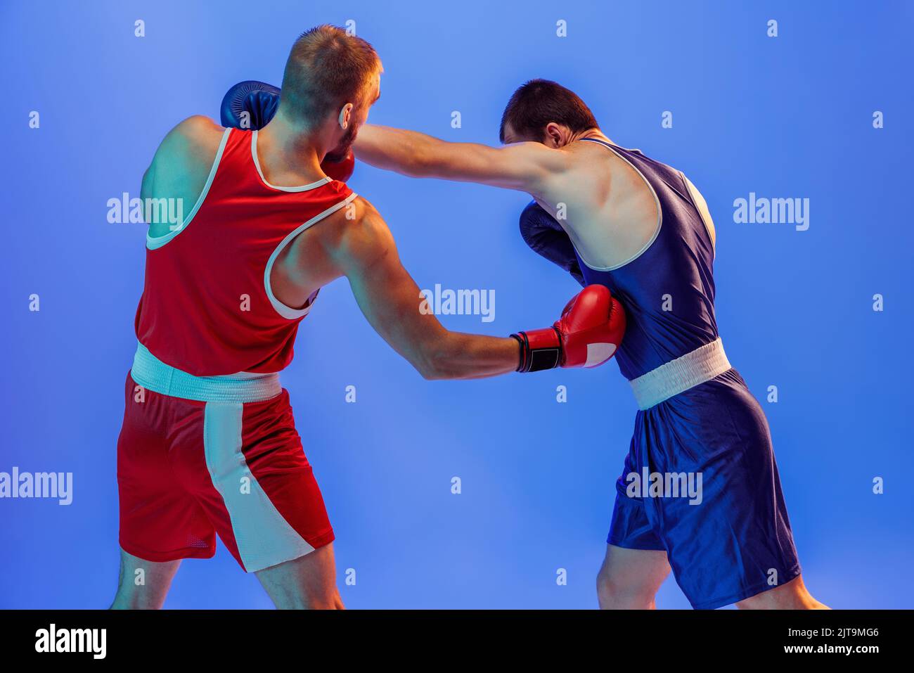 Left hook. Male professional boxers in red and blue sports uniform ...