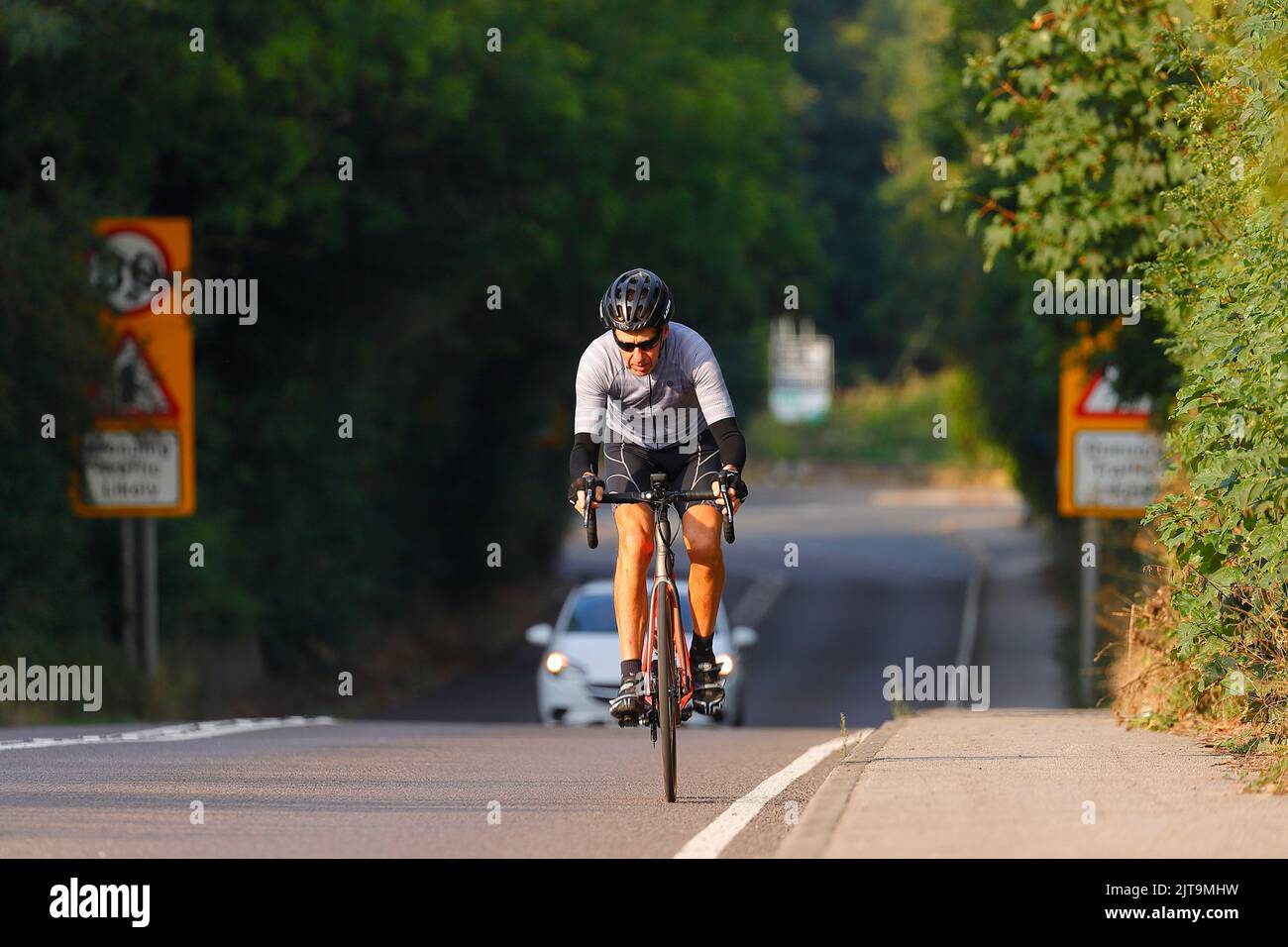 A cyclist on a main road in Swillington,West Yorkshire Stock Photo - Alamy