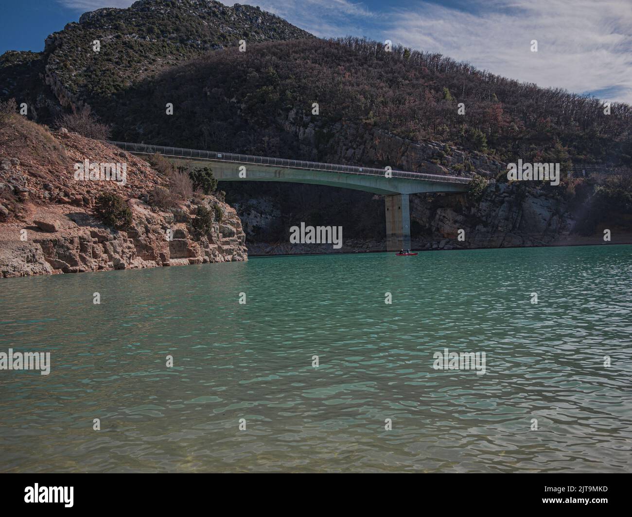 A scenery of a bridge connecting the hills over a lake Stock Photo - Alamy