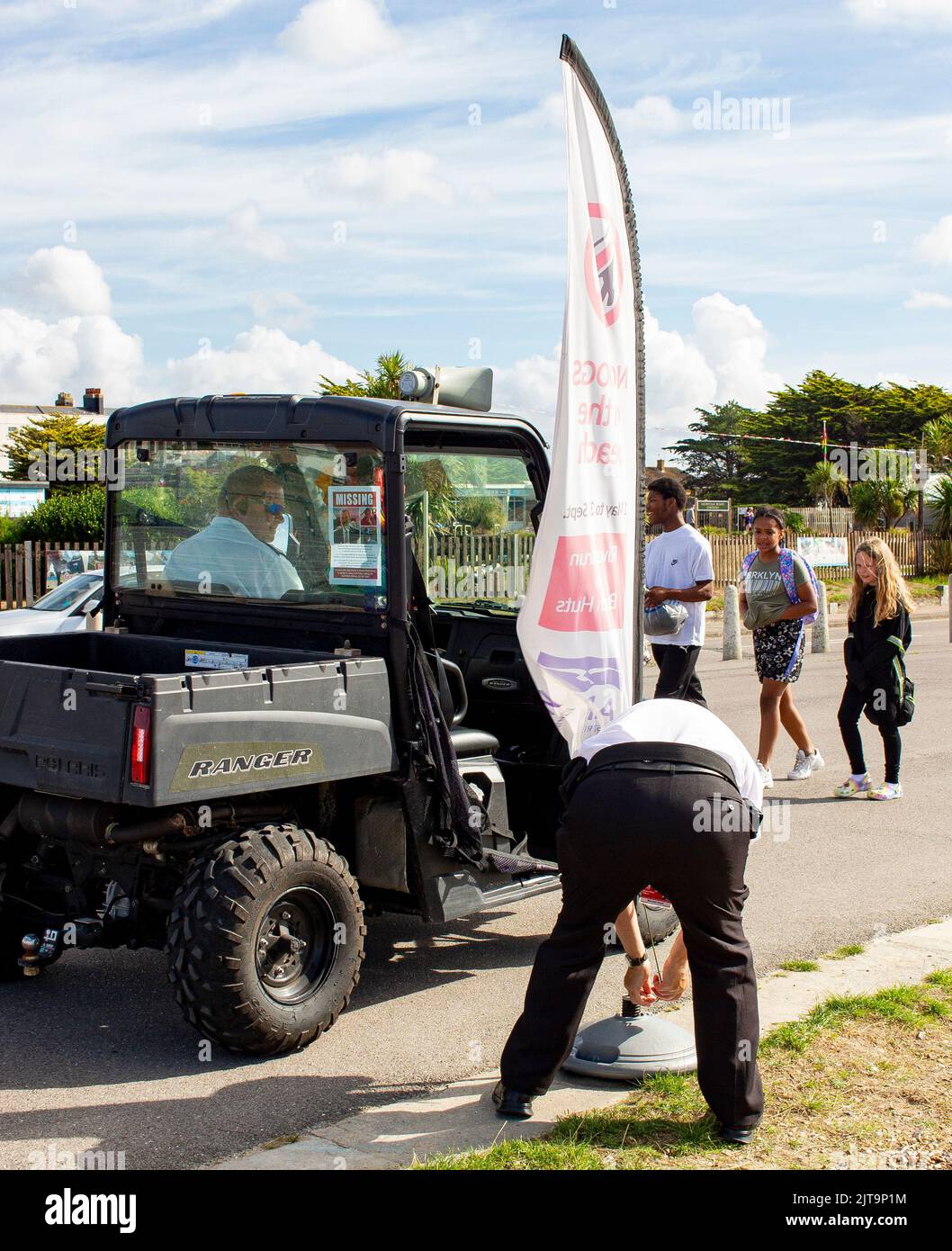 Council employee planting a safety flag on the promenade hi-res stock ...