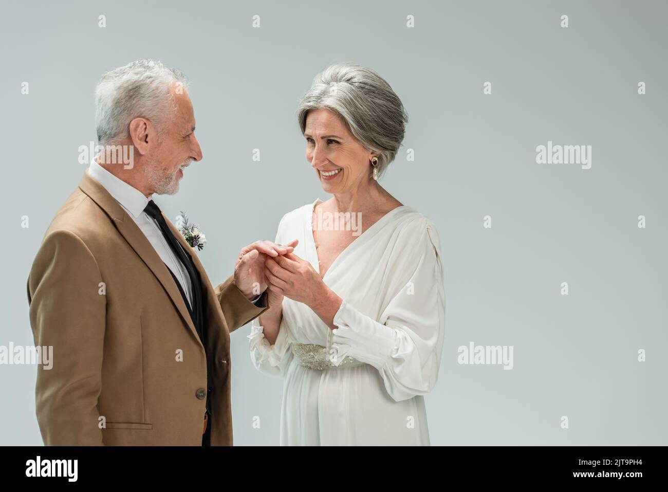 happy mature bride in white dress wearing engagement ring on finger of ...