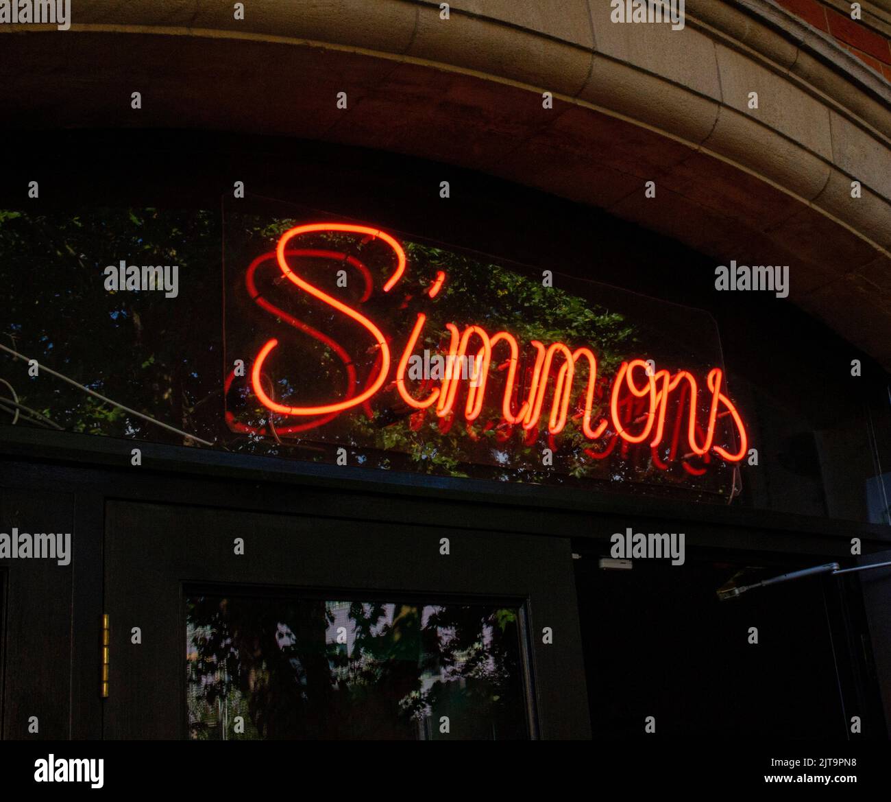 A neon sign - 'Simmons' - at the entrance to a bar in West London Stock ...
