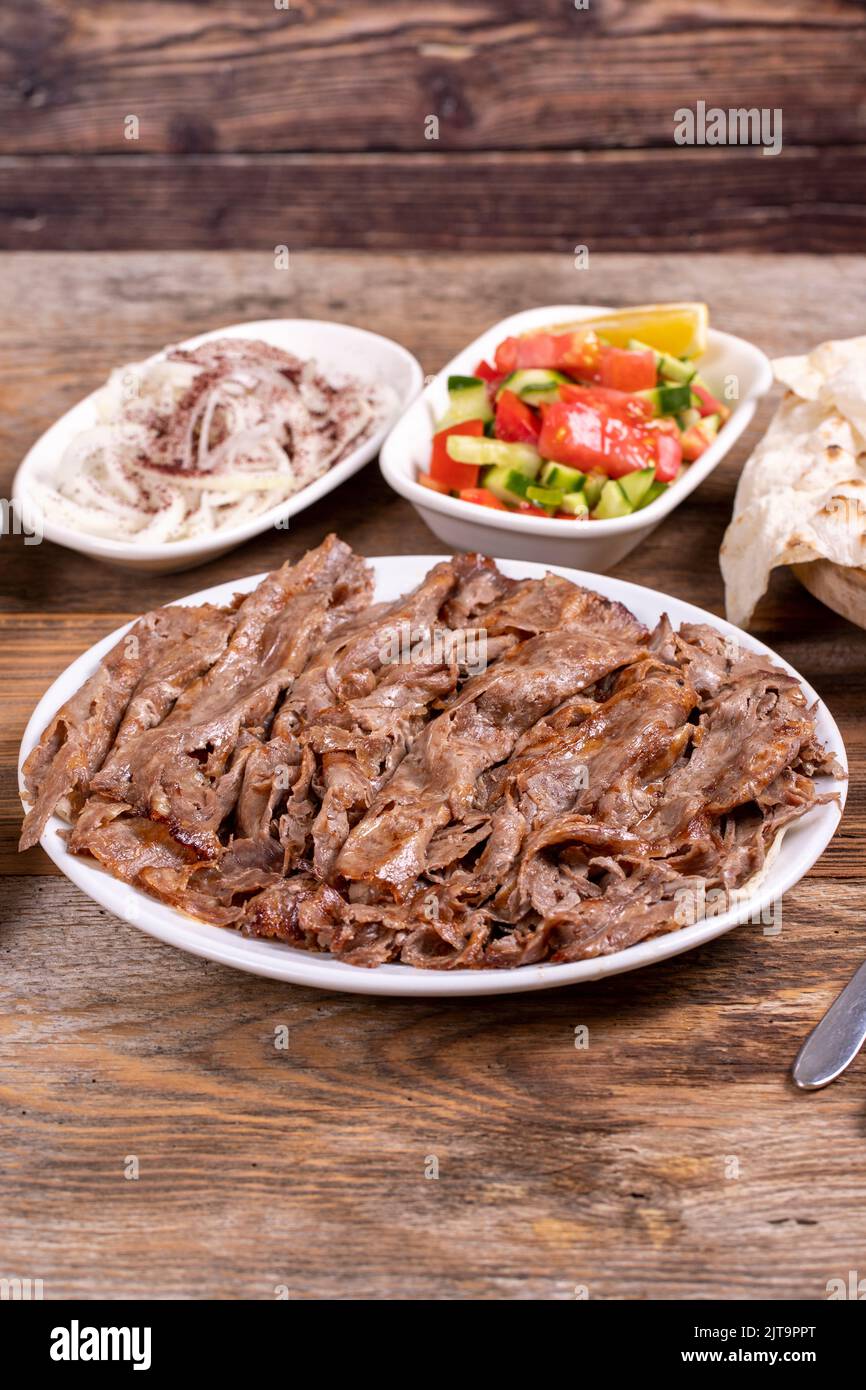 Meat doner kebab on the plate. Turkish meat doner kebab on wooden ...