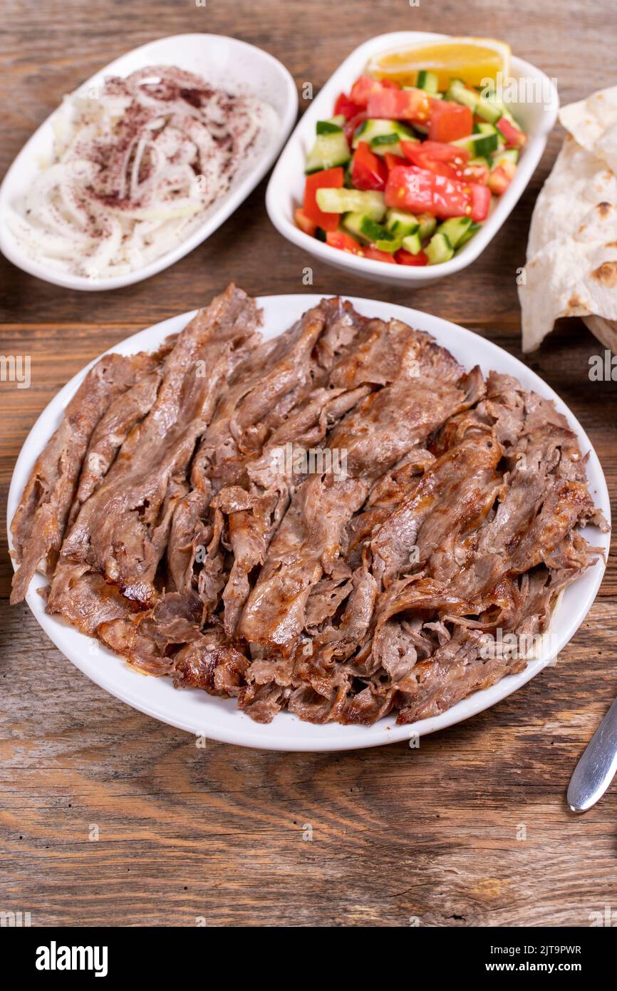 Meat doner kebab on the plate. Turkish meat doner kebab on wooden background. Traditional ...