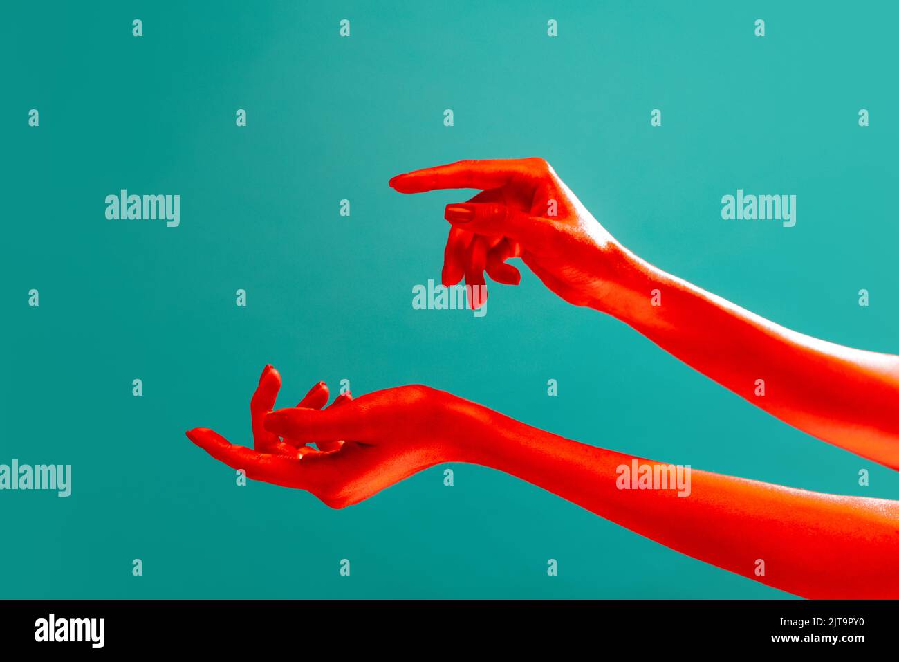 Authentic hands gesturing isolated on cyan color background in red neon ...