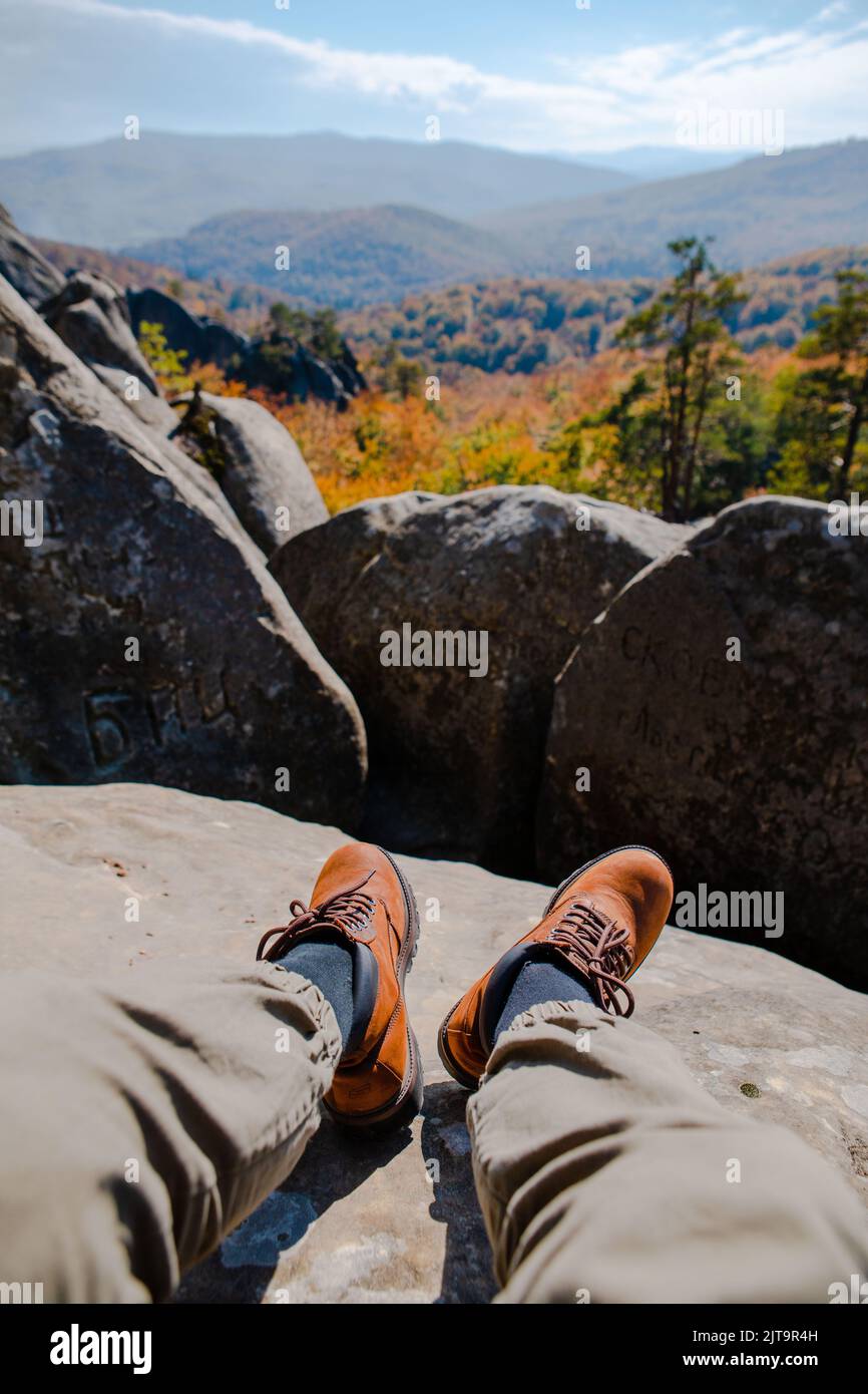 hiking concept men legs in boots on the rock Stock Photo - Alamy