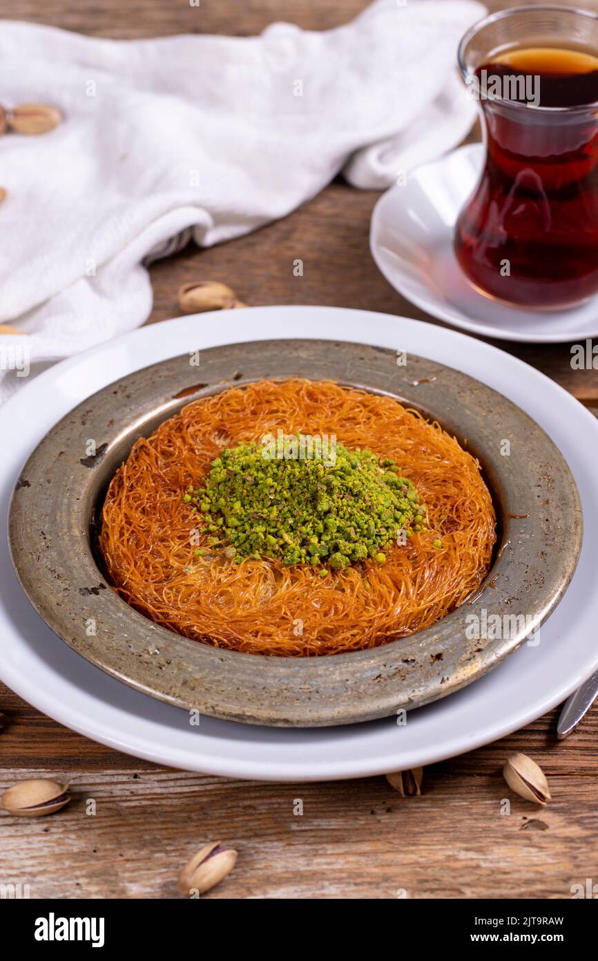 Kunefe. Traditional Turkish cuisine. Kunefe with pistachio on wooden ...