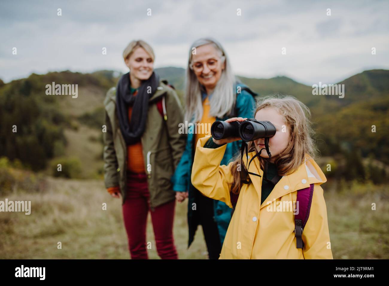 Small girl with mother and grandmother hiking outoors in nature Stock ...
