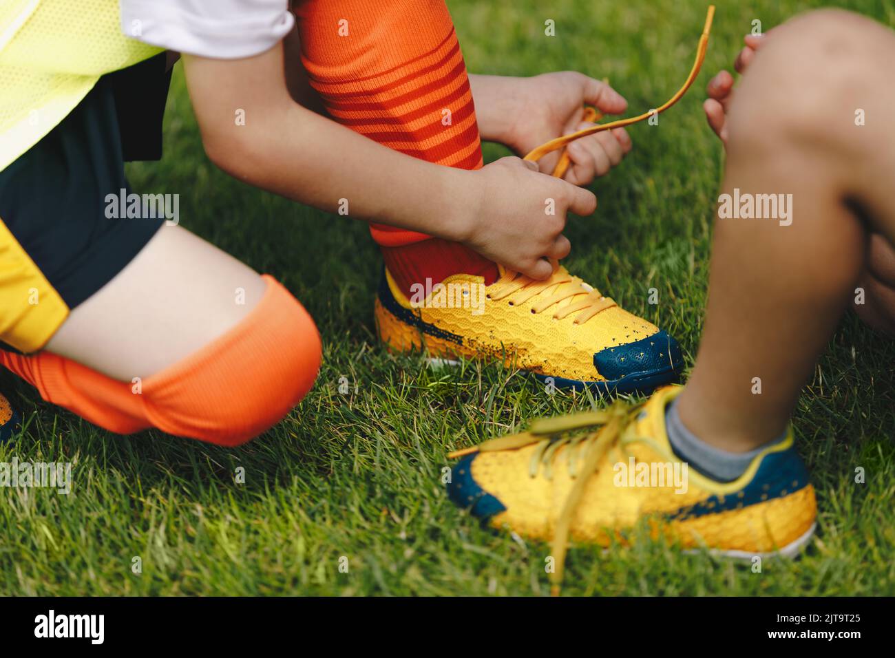 Children tying shoe laces. Kids in sports football team tying soccer ...