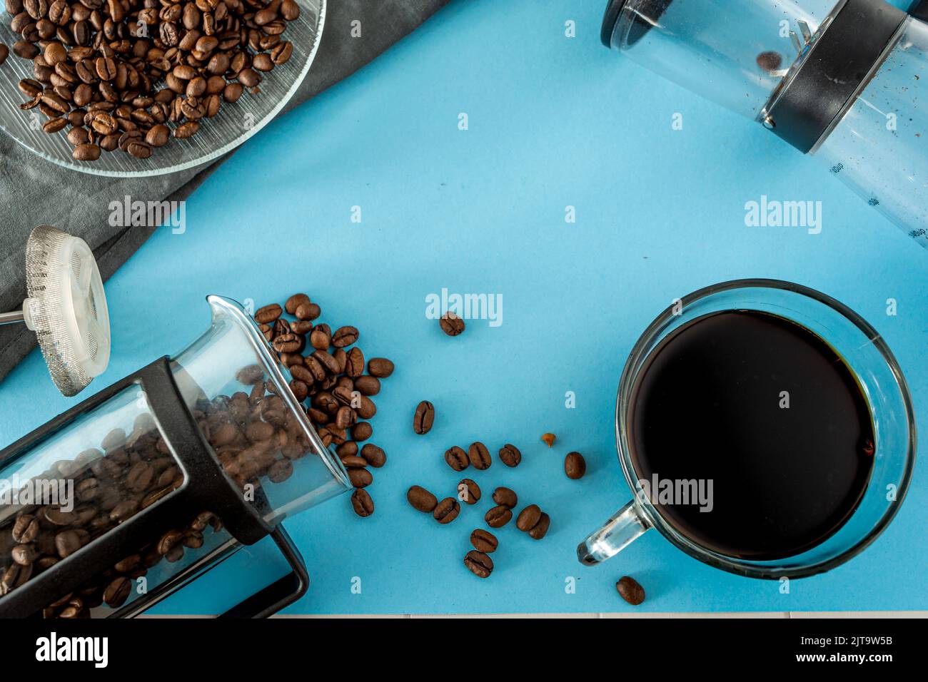 black coffee and beans, also elements over blue background. top view ...