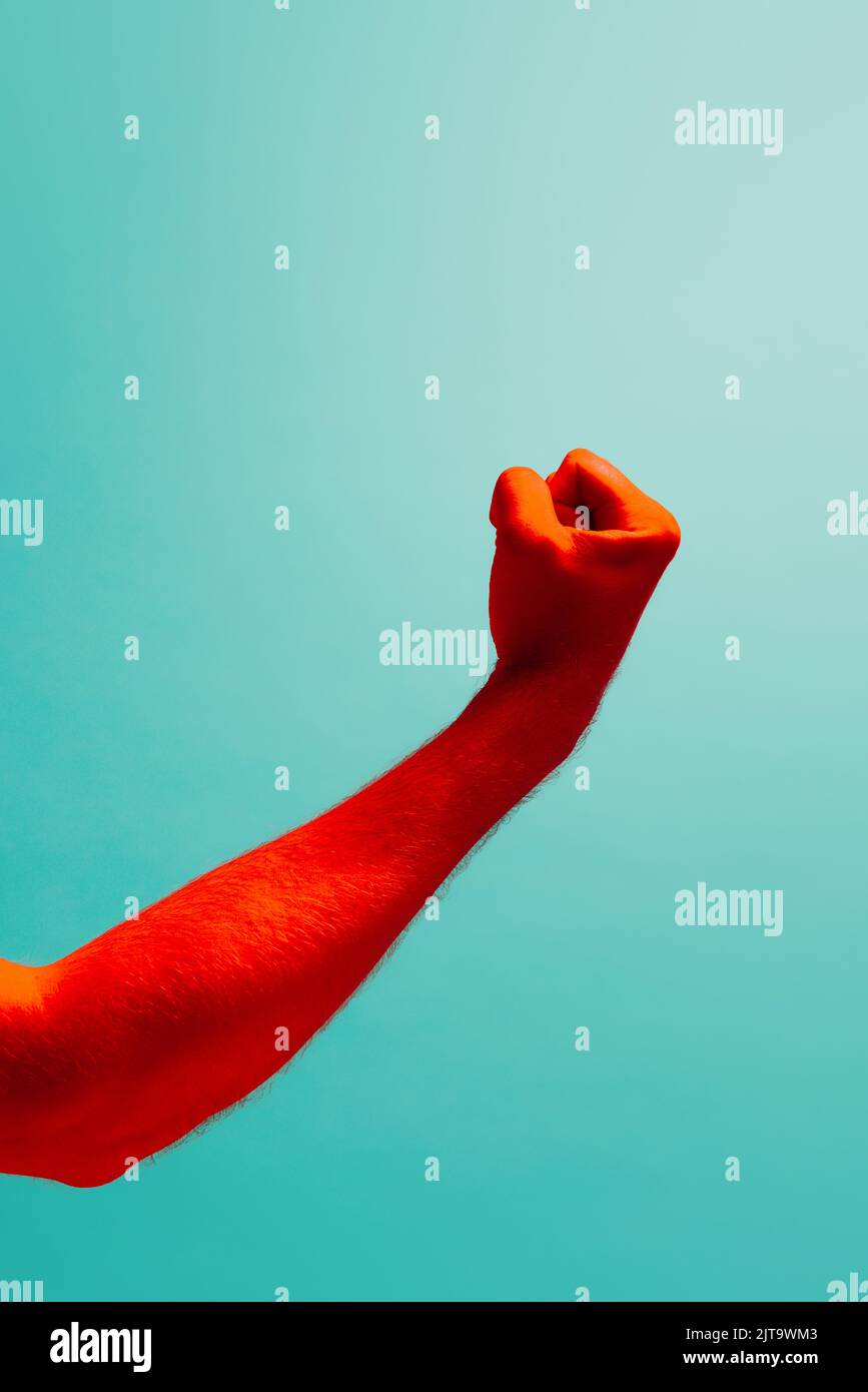 The threat. Man's hand clenched into fist isolated on light blue ...