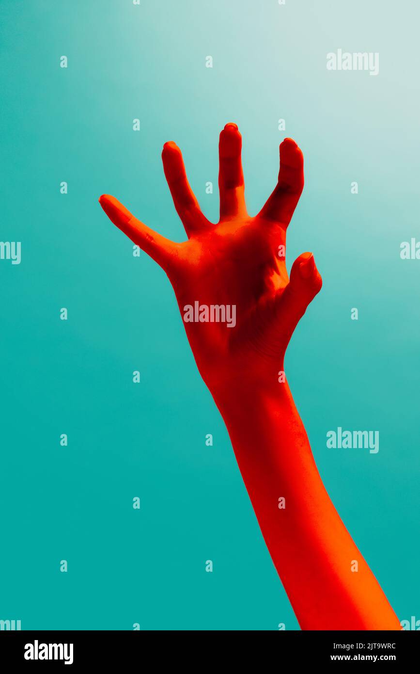 Intimidate. Female hand gesturing isolated on cyan color background in ...