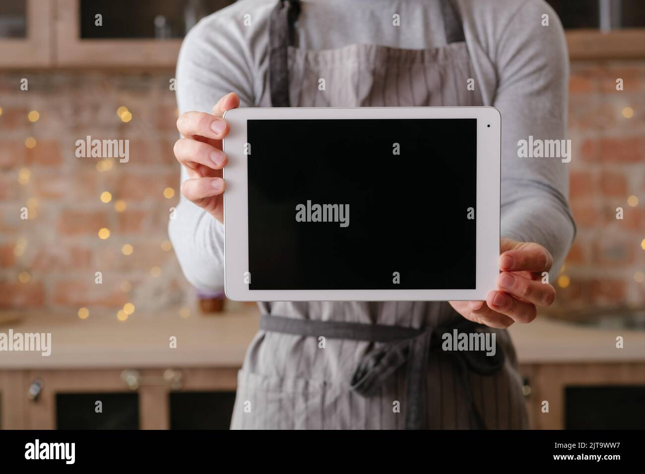 online recipe tablet screen man loft kitchen Stock Photo - Alamy
