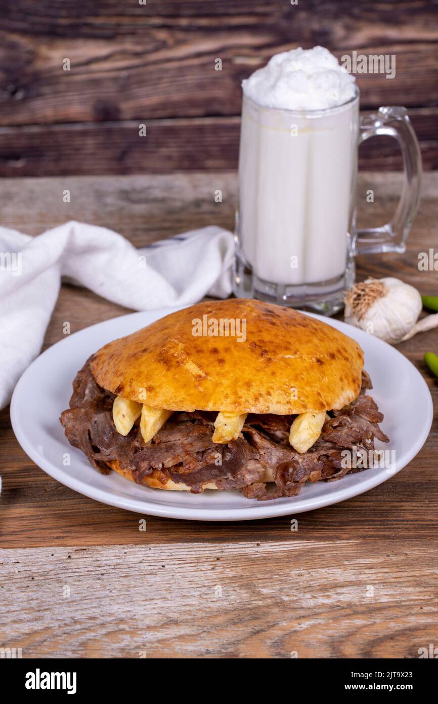 Meat between bread rolls. Meat doner in fat bread on wooden background ...