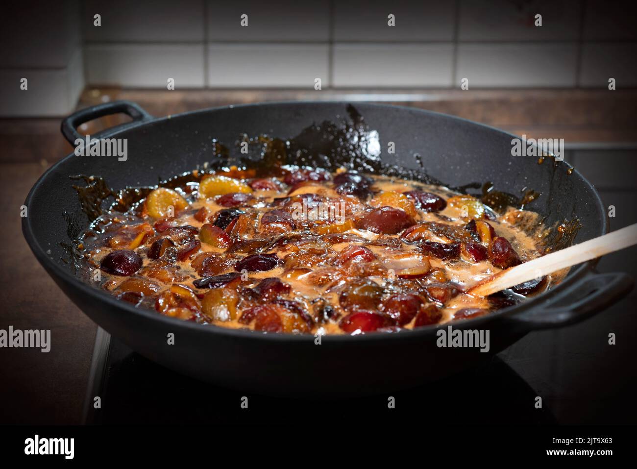 The process of boiling plum jam in a cast iron pan Stock Photo - Alamy