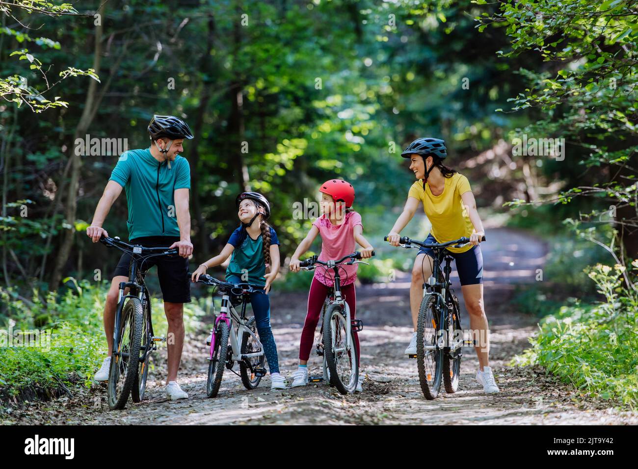 Young family with little children preapring for bike ride, standing ...