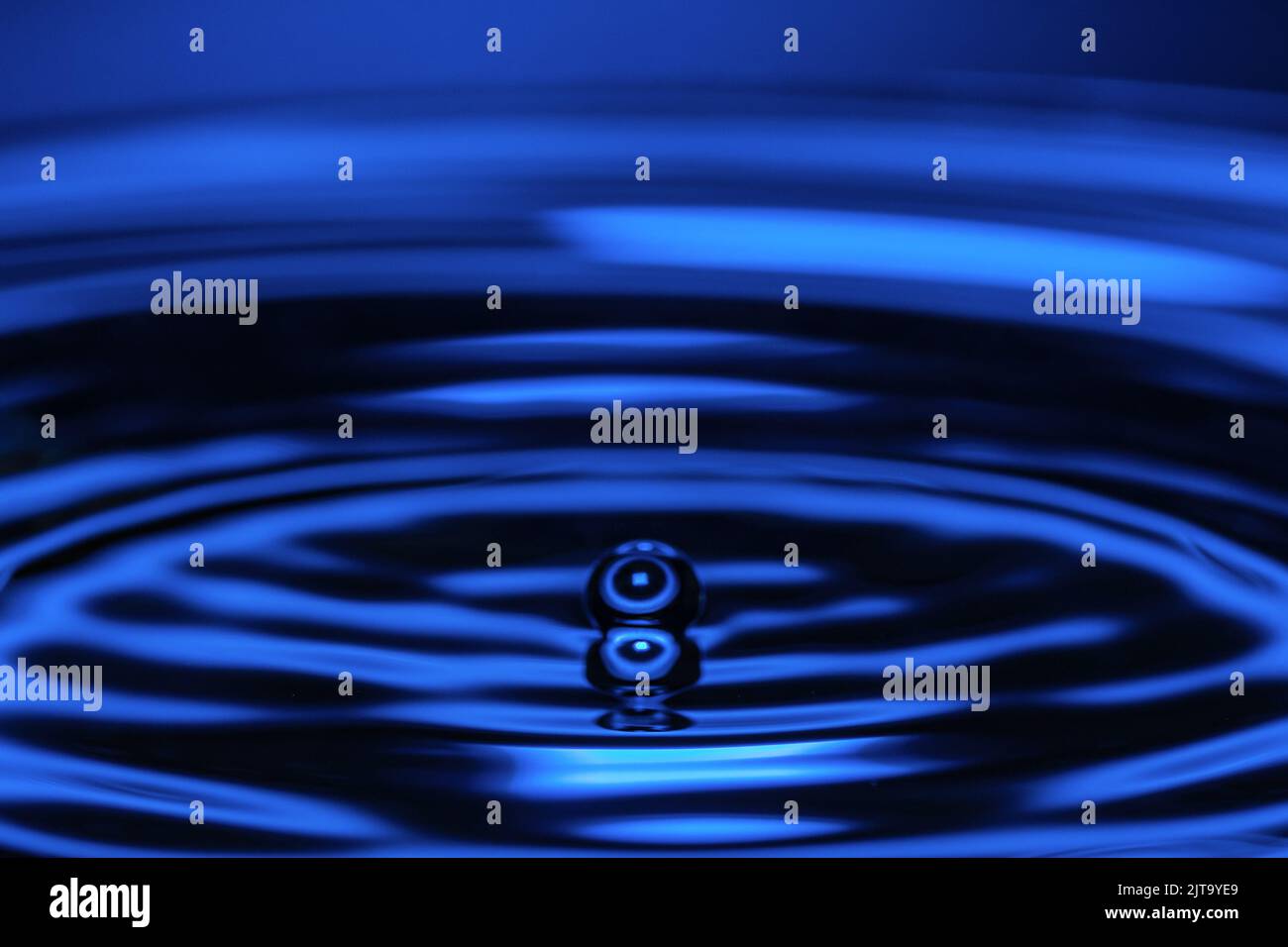 Macro water drop on a blue background and circles on it. Round water ...