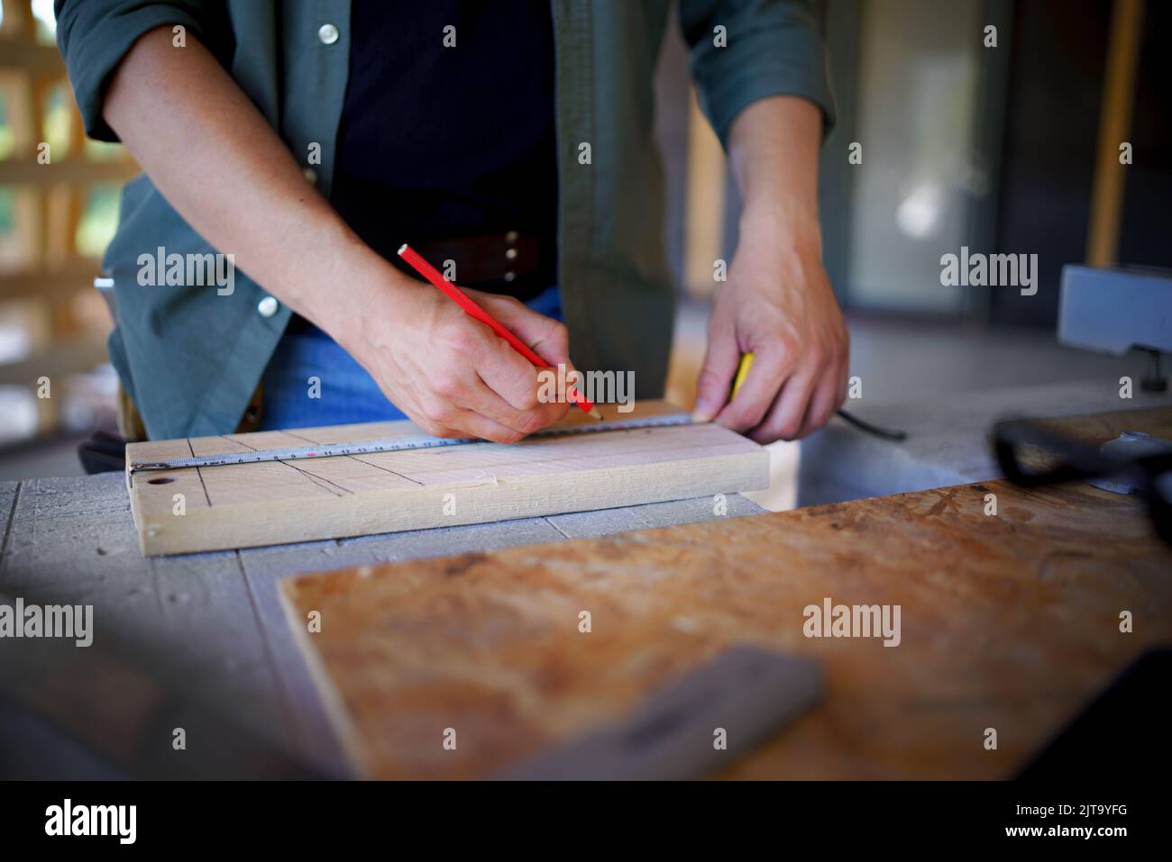 Carpenter measuring wooden planks and making marks with pencil, diy eco ...