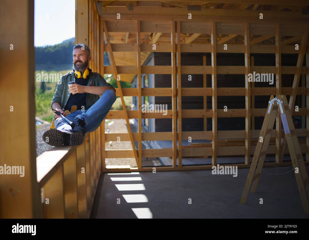 Handyman resting and having break when working on wooden construction ...