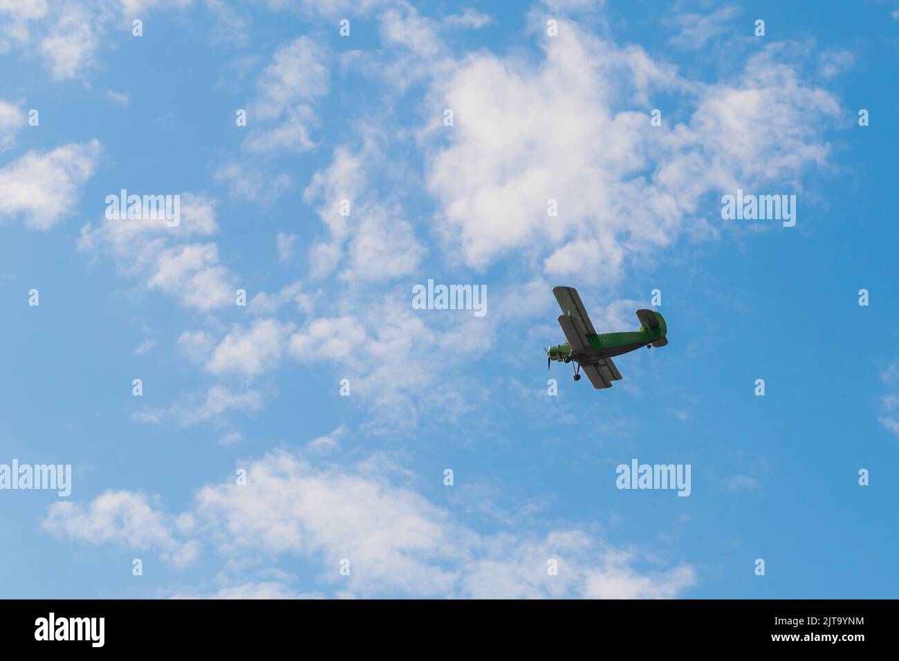Biplane flying in blue sky during air show Stock Photo - Alamy