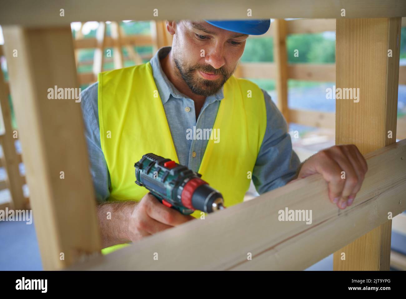 Construction worker working with screwdriver on wooden frame, diy eco ...