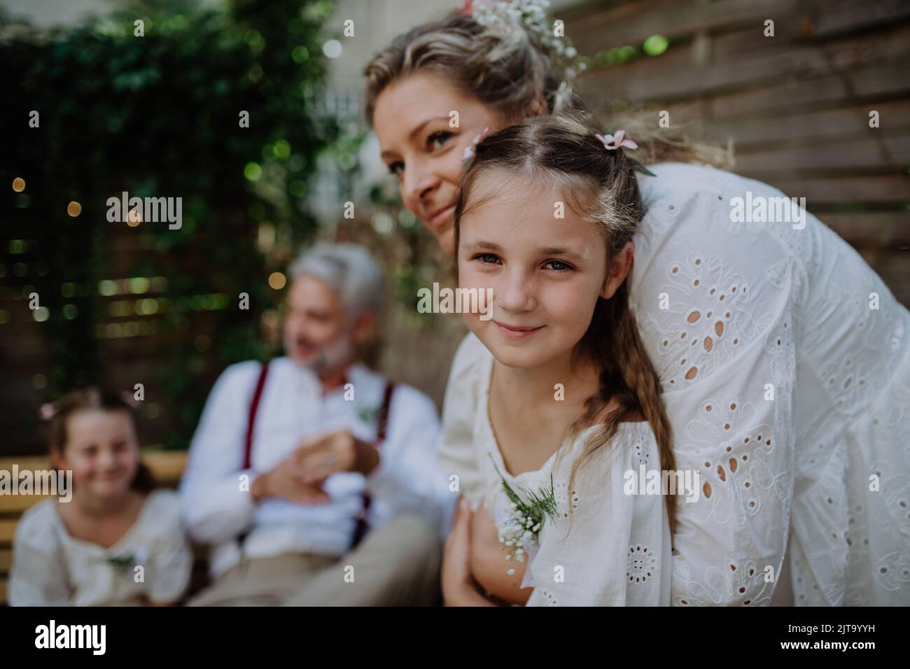 Mature bride and groom receiving congratulations from their little ...