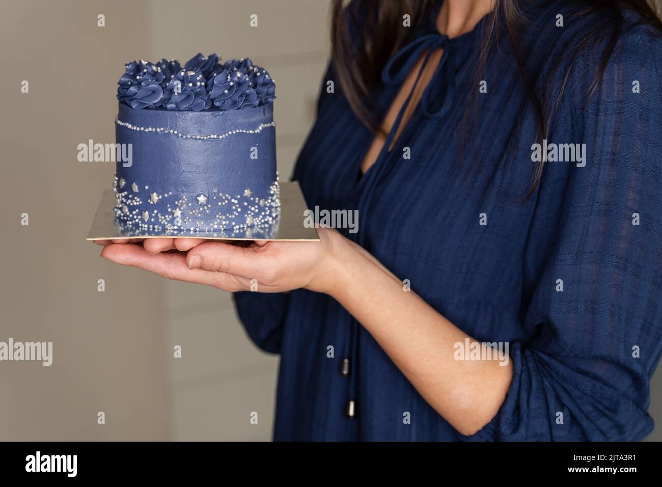 Young baker woman holding sweets showing a copy space on a palm Stock ...