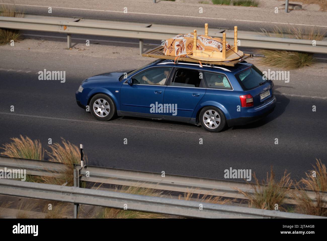 Car carrying furnitures on its roof on A7 highway. Malaga province ...