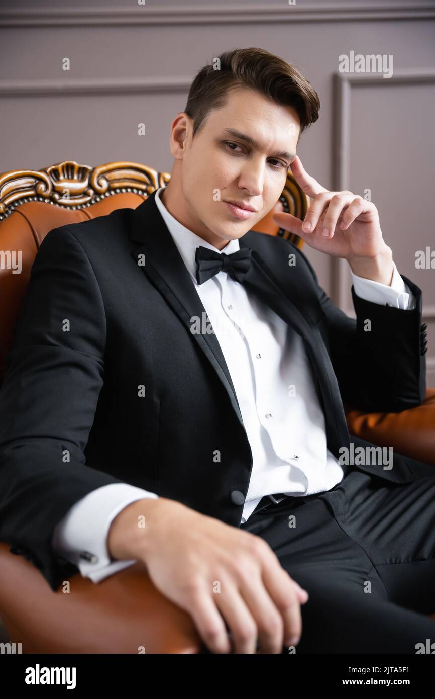 Elegant man in suit sitting on leather armchair at home Stock Photo - Alamy