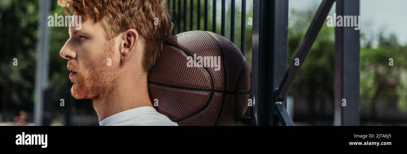 side view of basketball player with ball near fence, banner Stock Photo ...