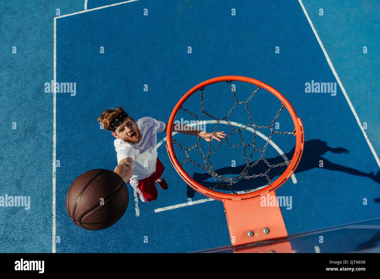 top view of young excited man throwing ball into basketball ring Stock ...
