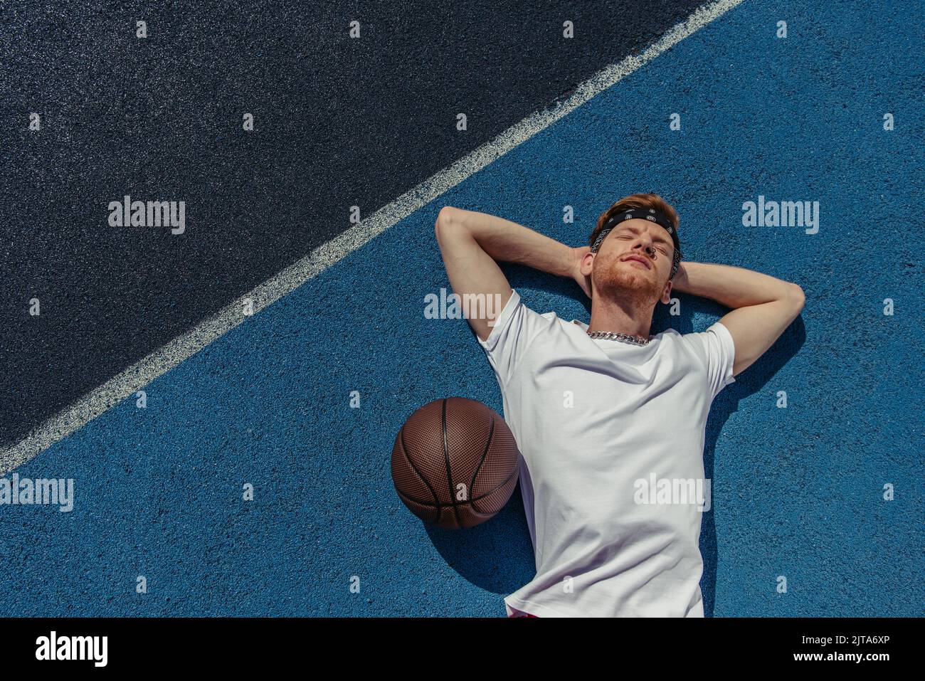top view of young basketball player relaxing on court near ball Stock ...