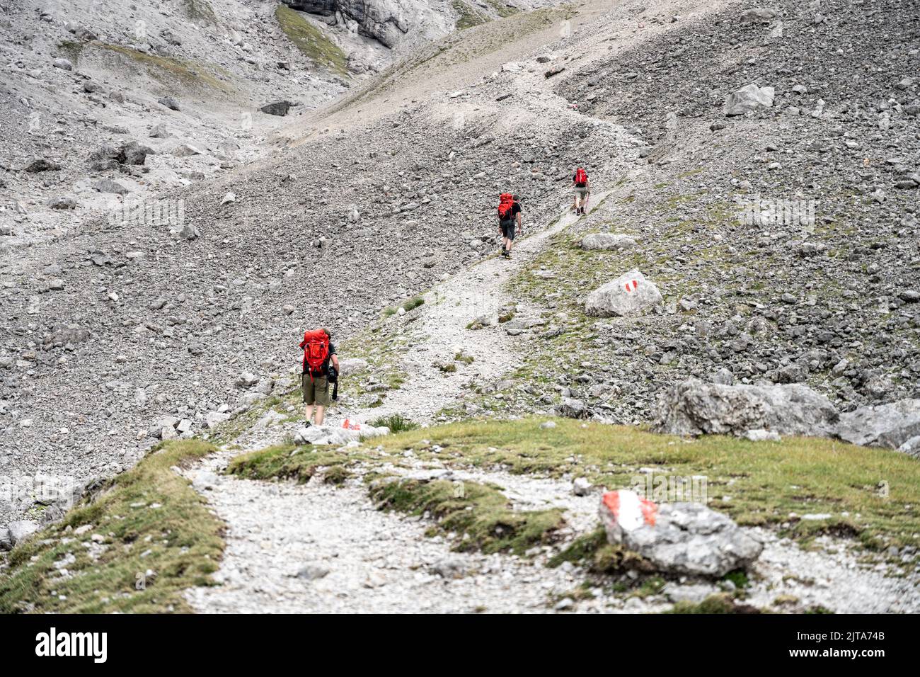 Group of three men in the mountains Stock Photo - Alamy