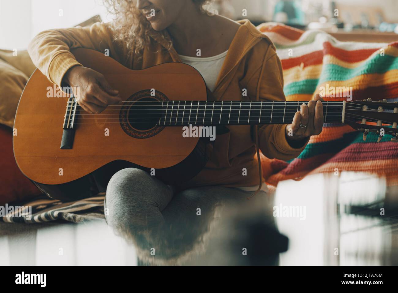 One woman at home playing guitar and having fun alone in relax leisure ...