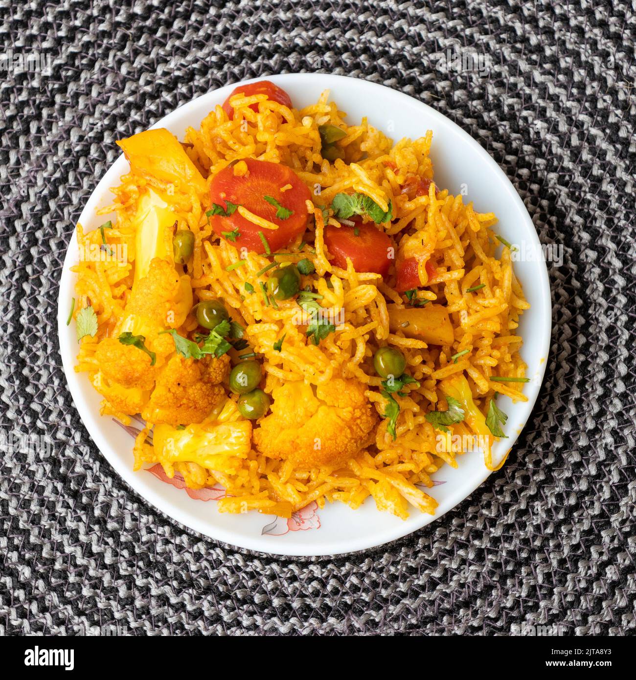 Indian vegetarian fried rice in the plate with carrot, spring onion ...