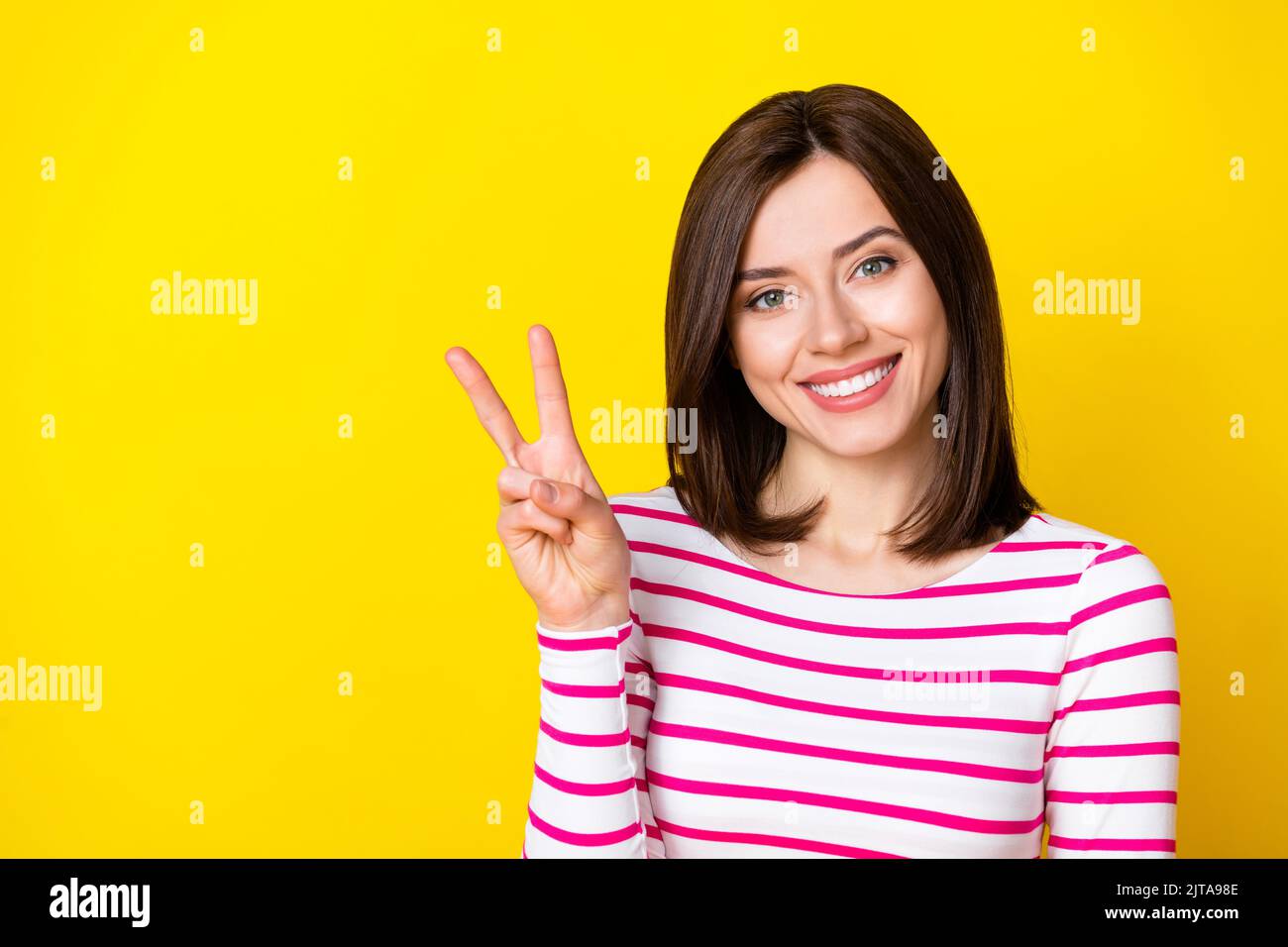 Photo portrait of cheerful young lady smiling show v-sign photo empty ...