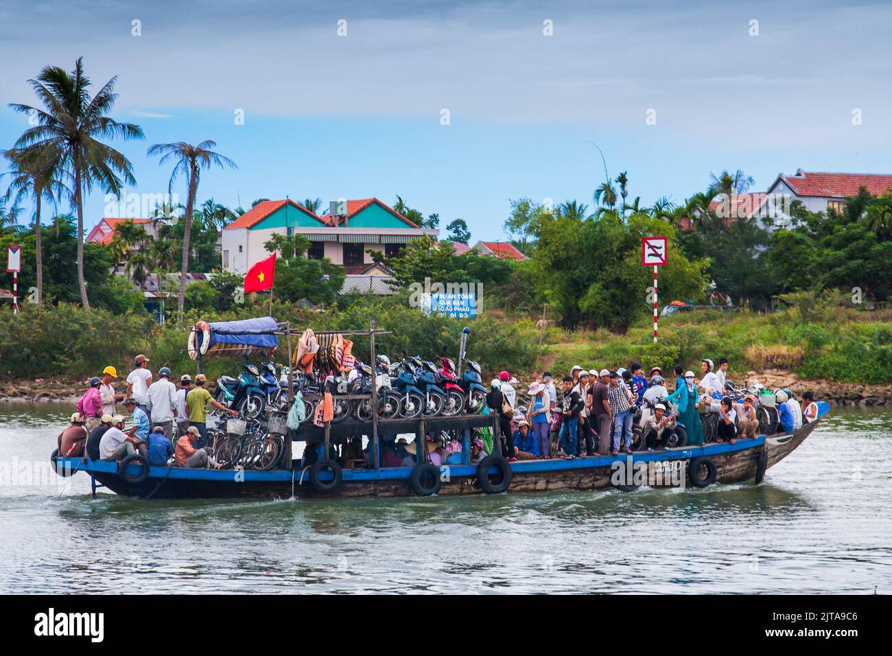 Vietnam, Hoi An Ferry boat bringing people and their mopeds to one of ...