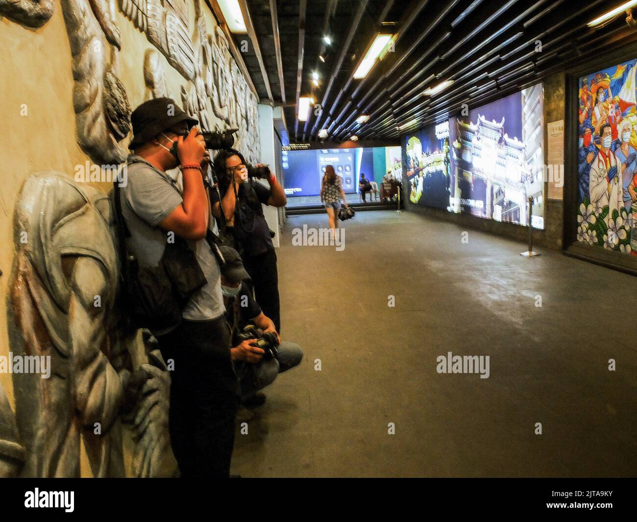 A Filipino Photojournalists takes photos of murals in Lagusnilad ...