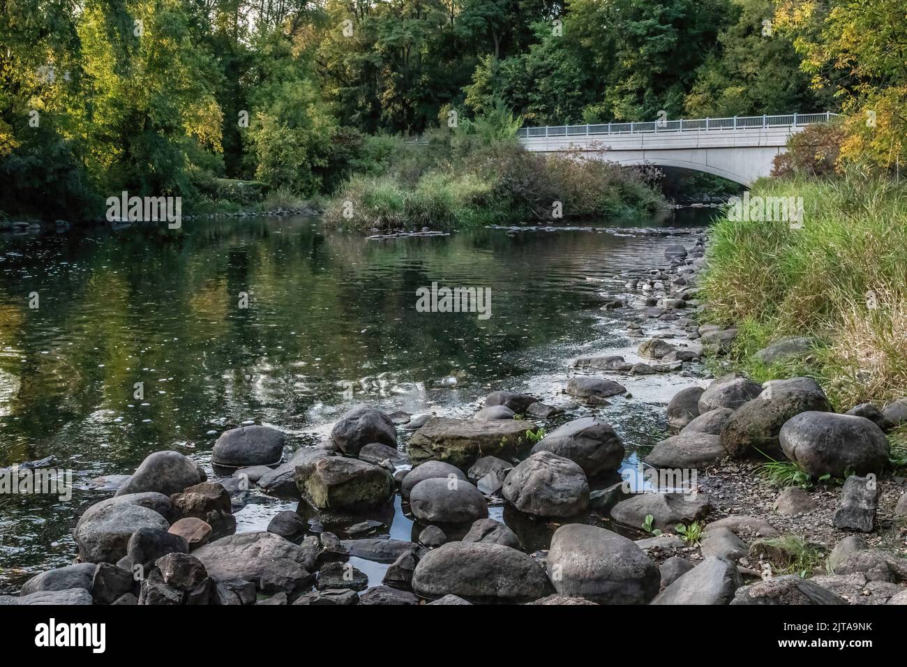 Stones on the edge of the Sunrise River leading to a bridge over the ...