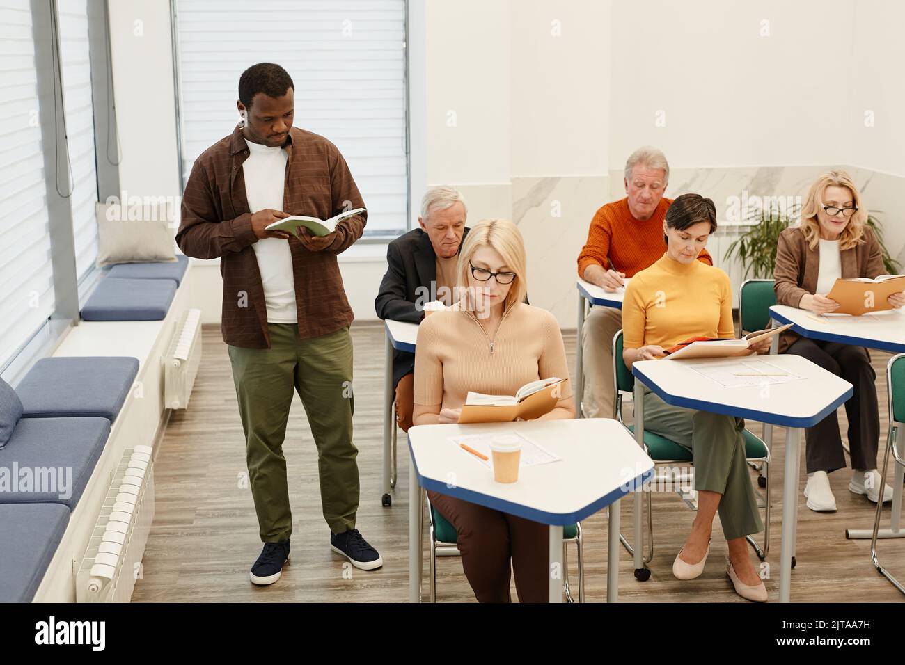 African teacher giving lecture for senior students while they sitting ...