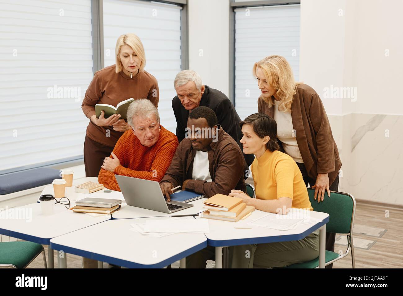 African teacher giving presentation on laptop for students while they ...