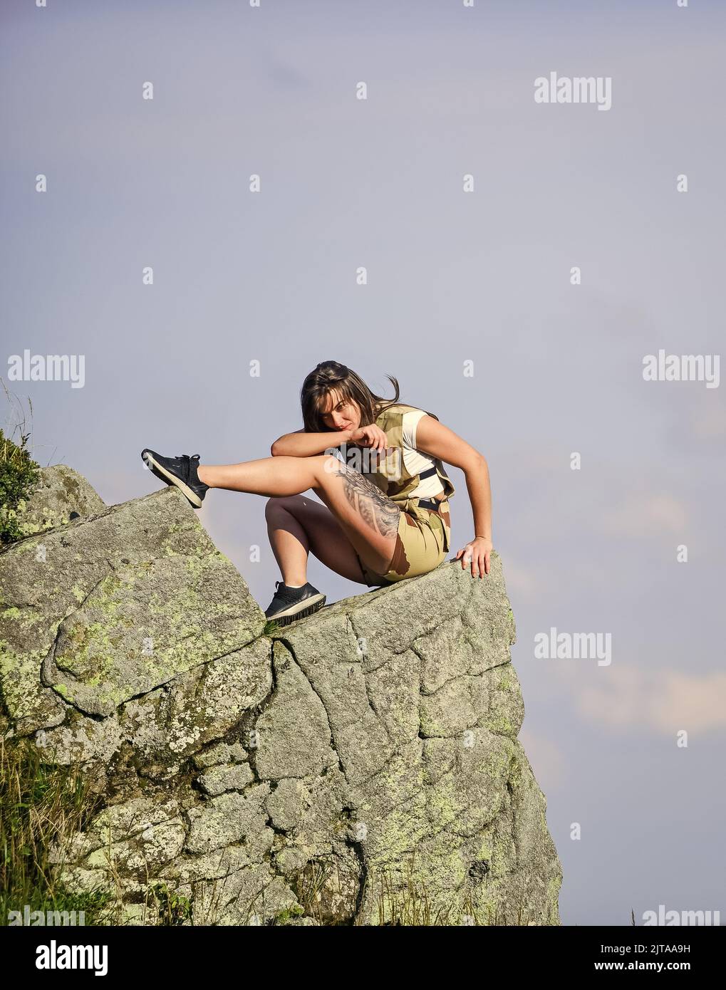 Enjoy the view. Tourist hiker girl relaxing edge cliff. Dangerous relax ...