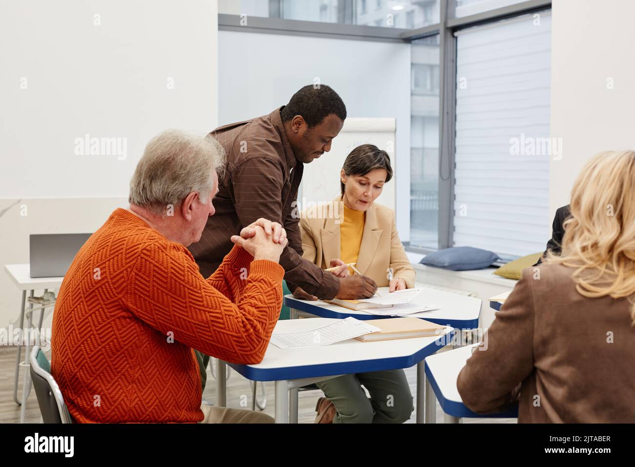 African teacher talking to students during lesson, he explaining them ...