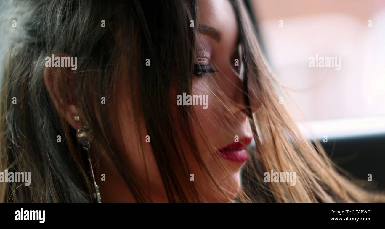 Attractive passenger girl face in backseat car, open windows wind ...