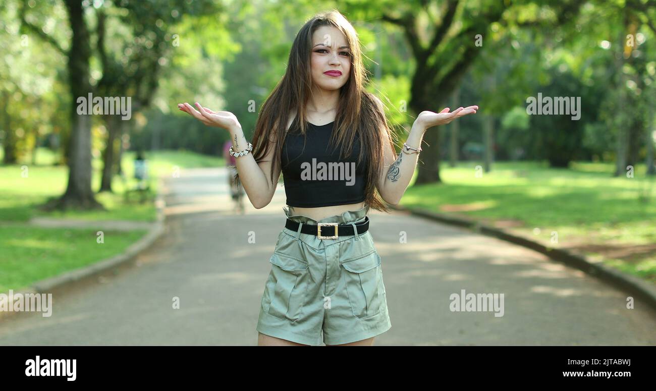 Annoyed confused millennial girl raising arms in disbelief in outdoor ...