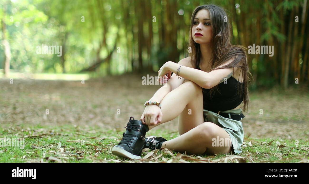 Contemplative young woman sitted in outdoor park thinking. Thoughtful ...