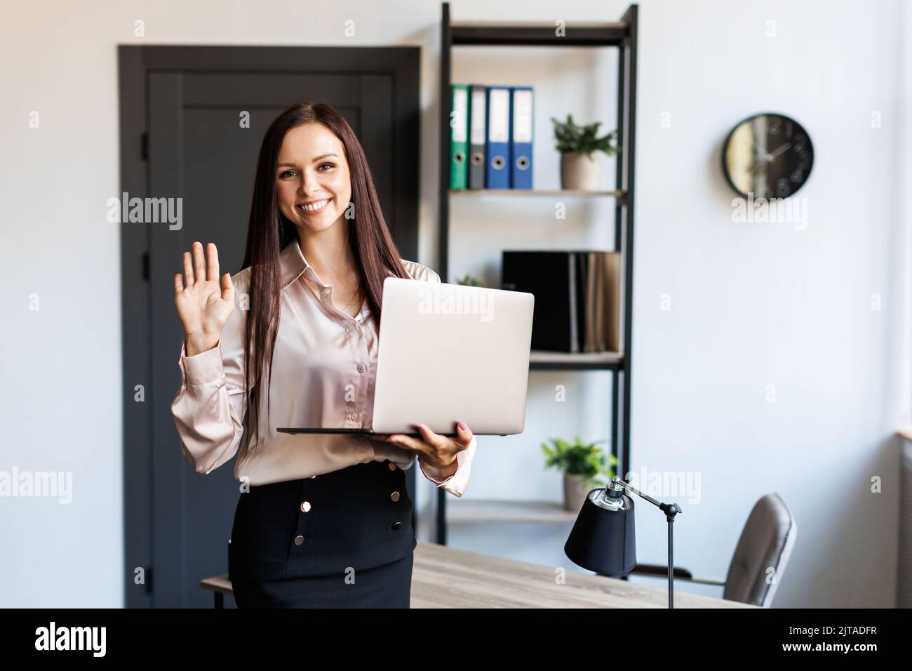 Adult successful female employee standing in modern office, hold a ...