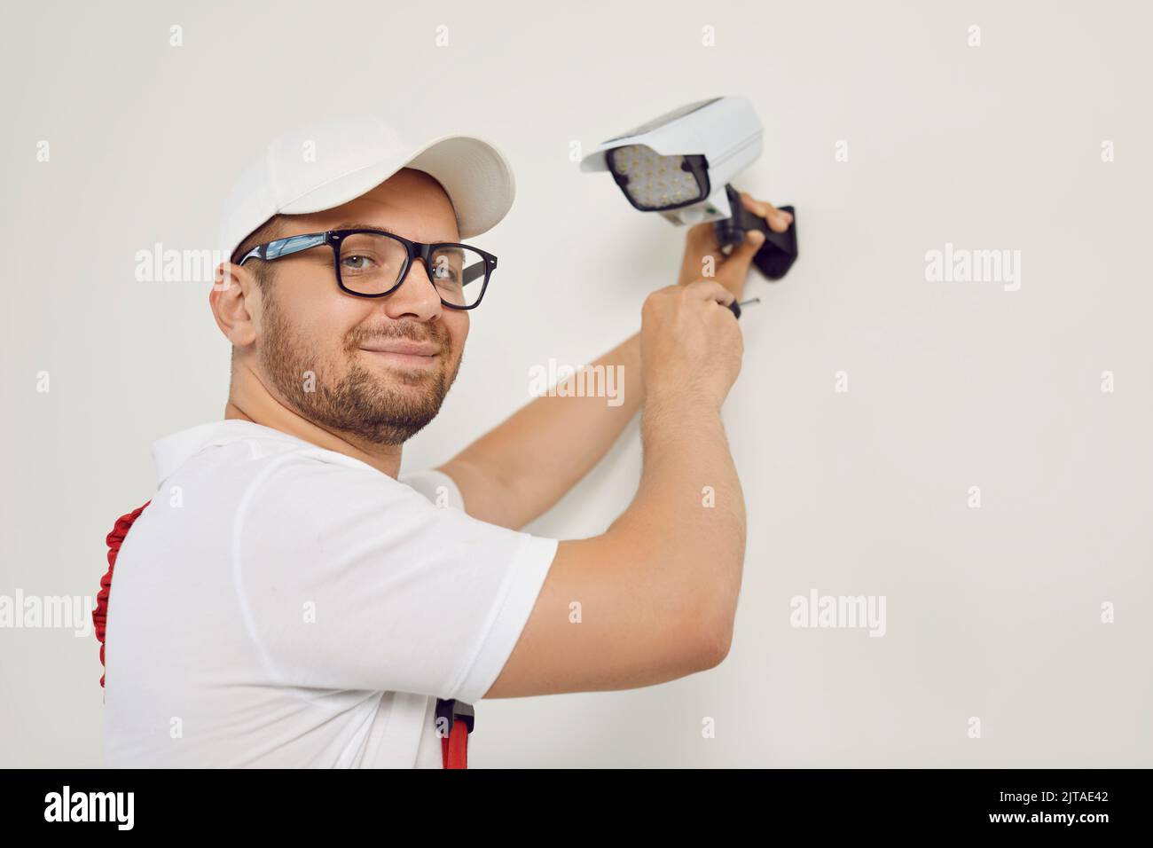 Portrait of smiling male technician worker who installing video ...